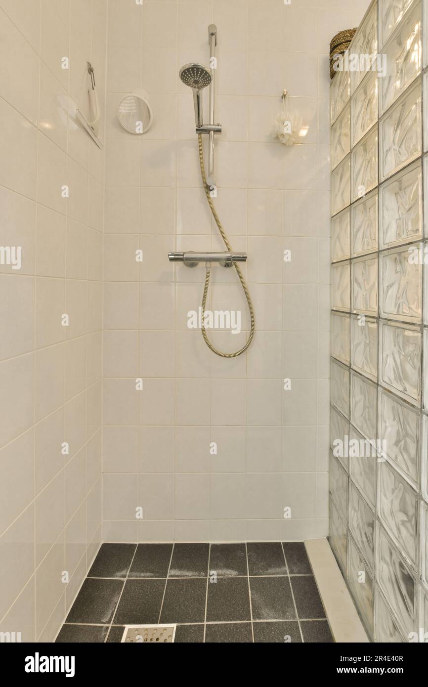 a shower with glass blocks on the wall and tiled floor in a white tile ...