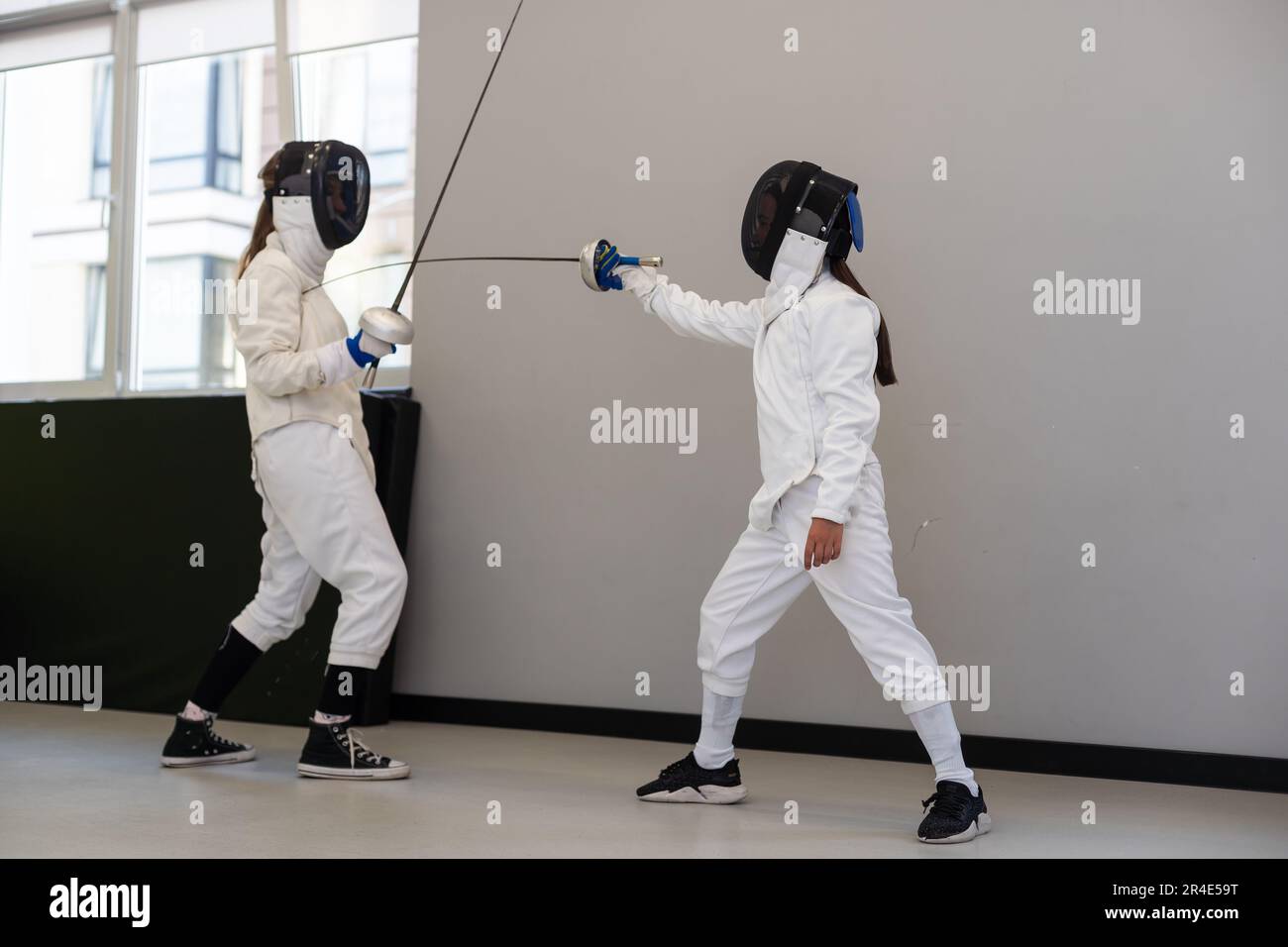 Two girl fencing athletes fight on professional sports arena Stock ...