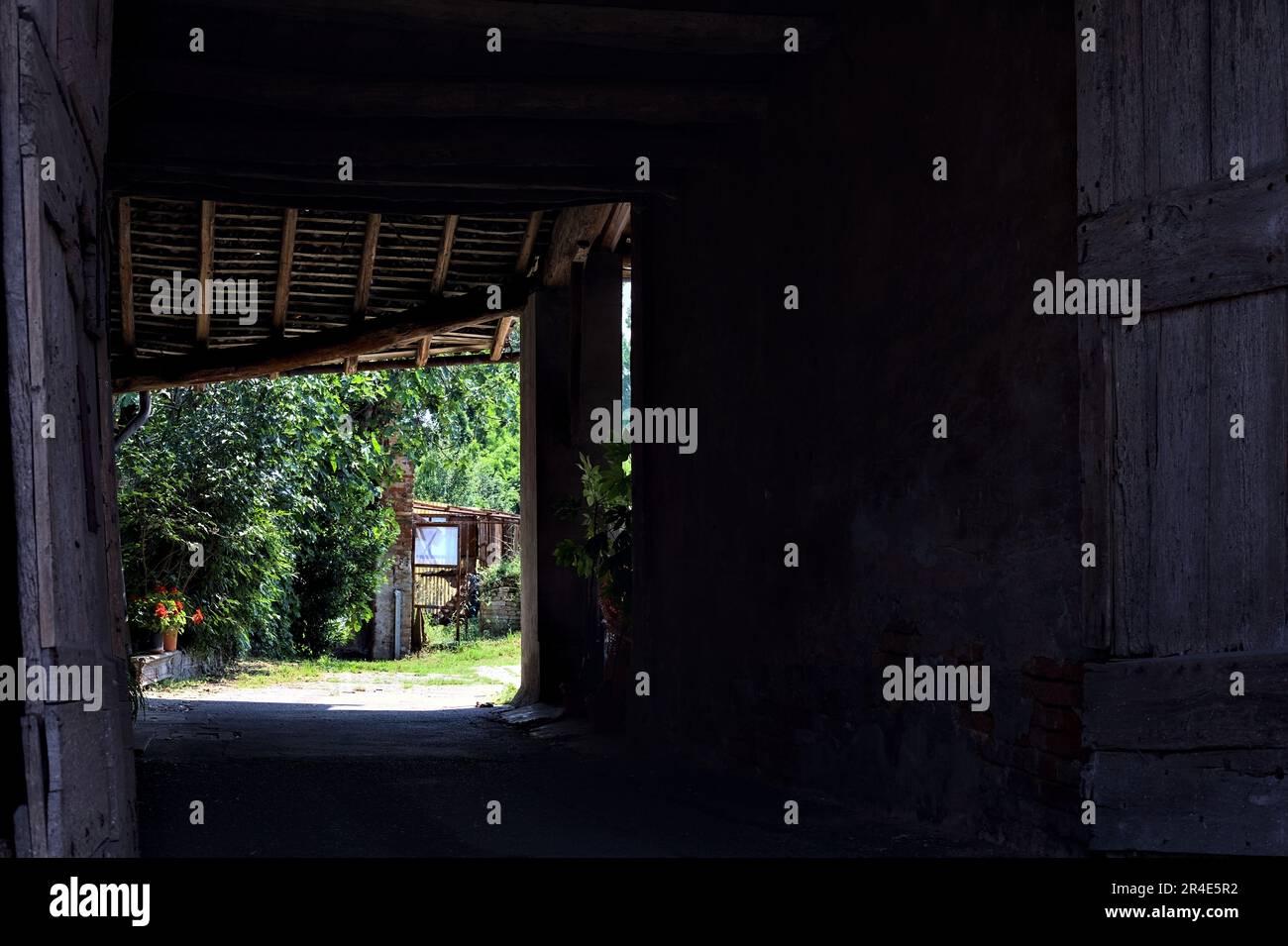 Covered alley that leads to a garden on a sunny day in a village in the ...