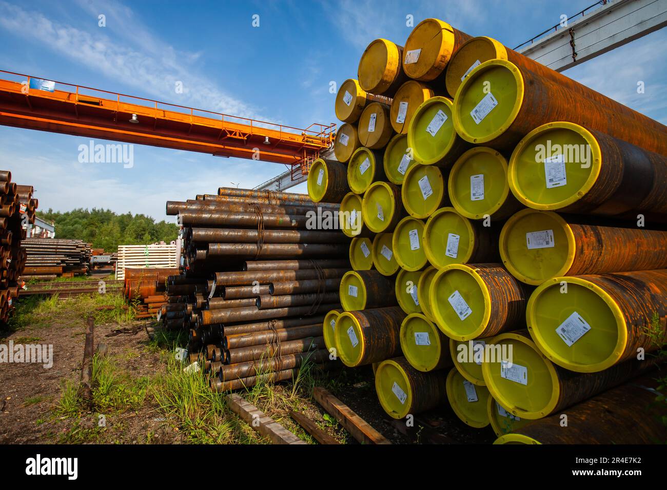 Steel pipes with green plastic caps on outdoor warehouse. Overhead ...
