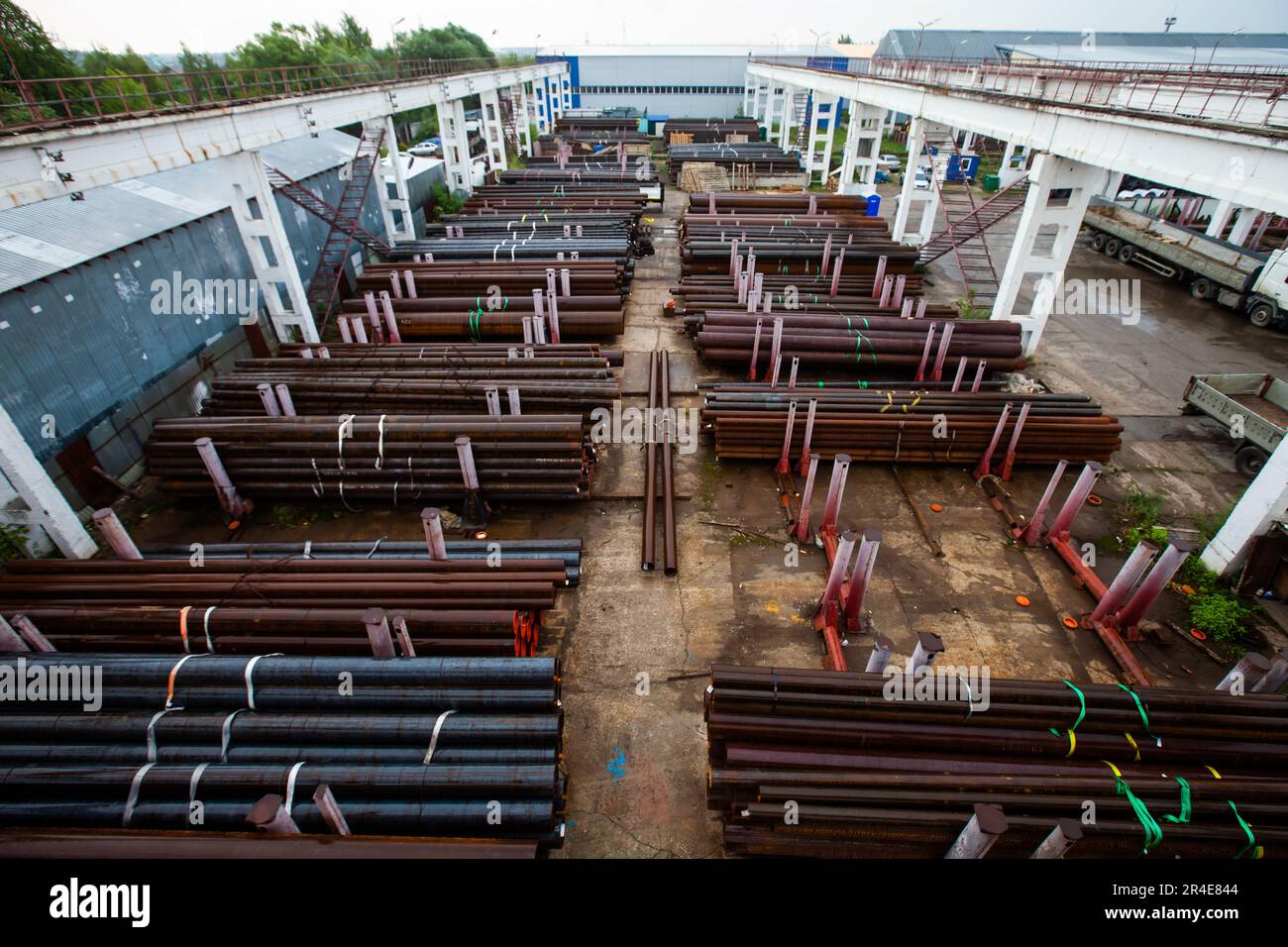 Steel pipes and tubes outdoor warehouse. Wet metal in rainy day. View ...