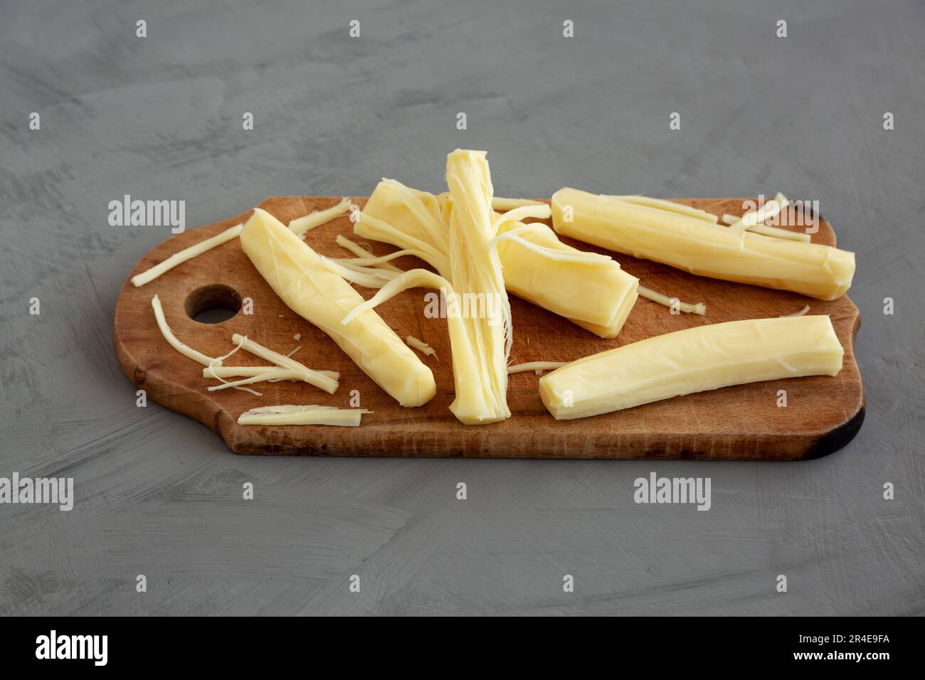 Organic String Cheese on a rustic wooden board on a gray background ...