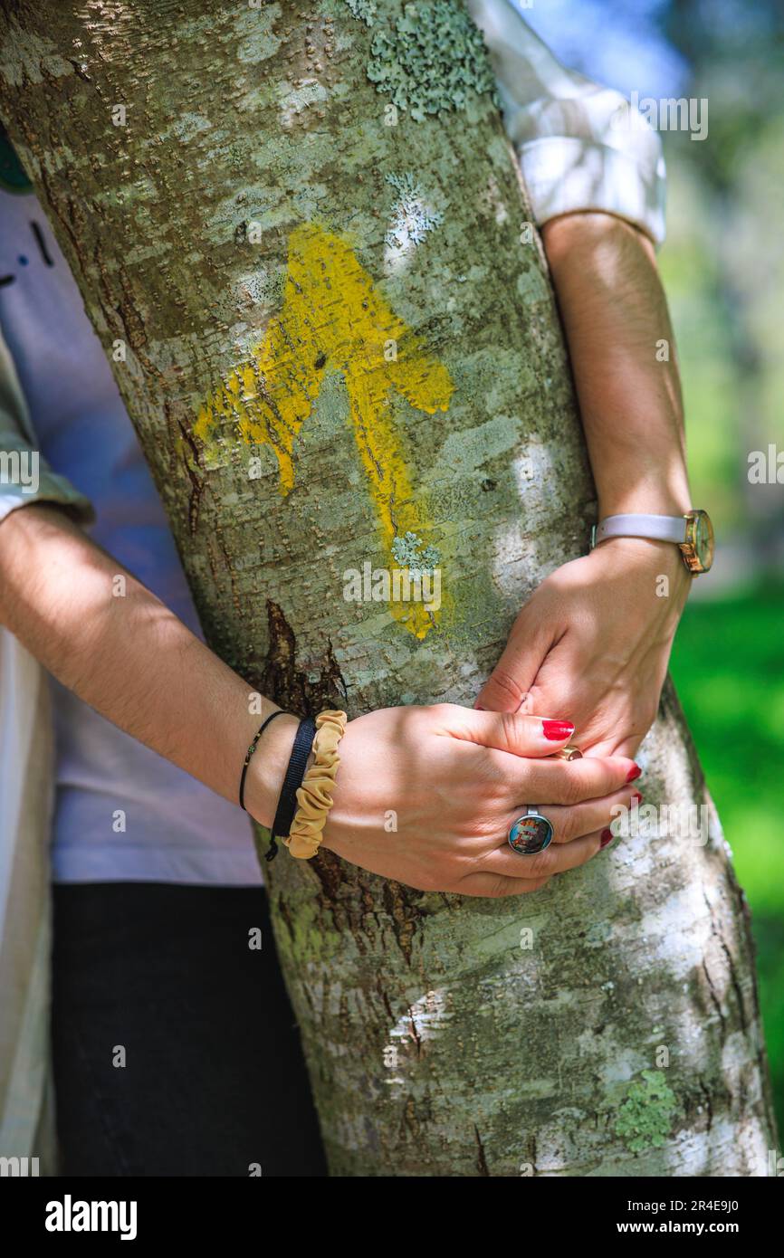 Woman hugging an Arrow sign leading The Way to Santiago painted on a ...