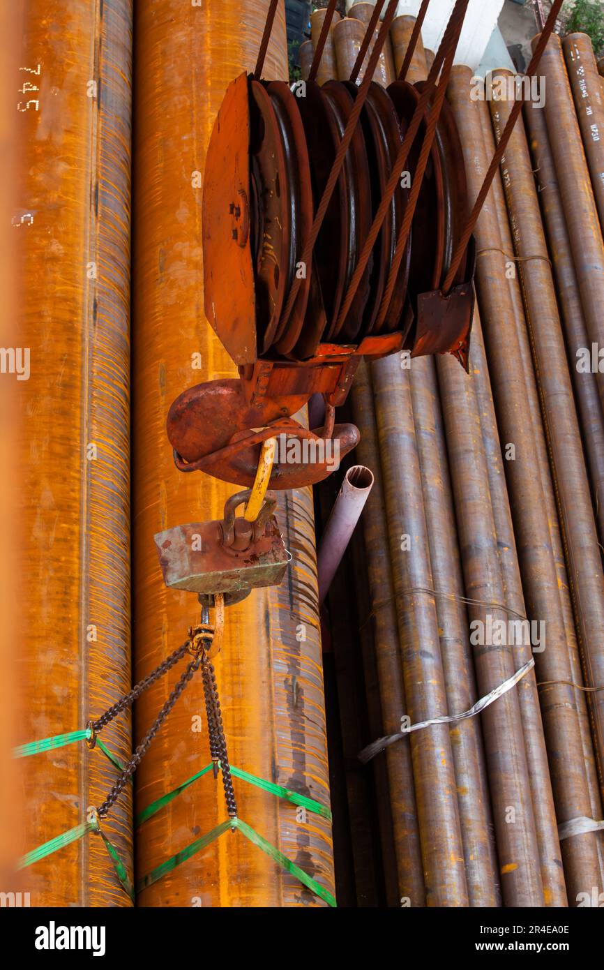 Rusted tubes and crane hook with green straps Stock Photo - Alamy