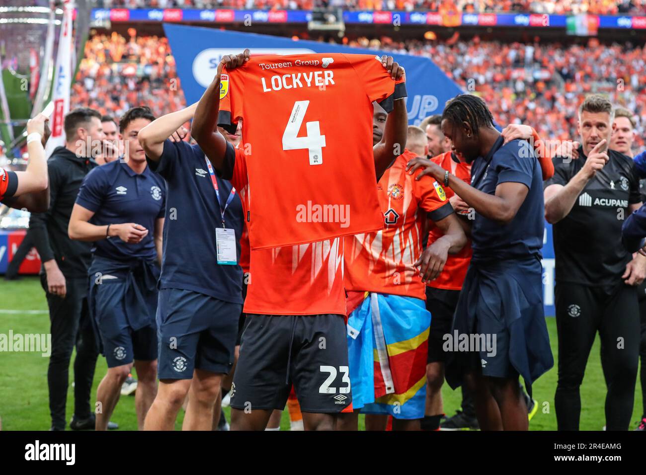 Luton Town players hold up Tom Lockyer #4 of Luton Town shirt after he ...
