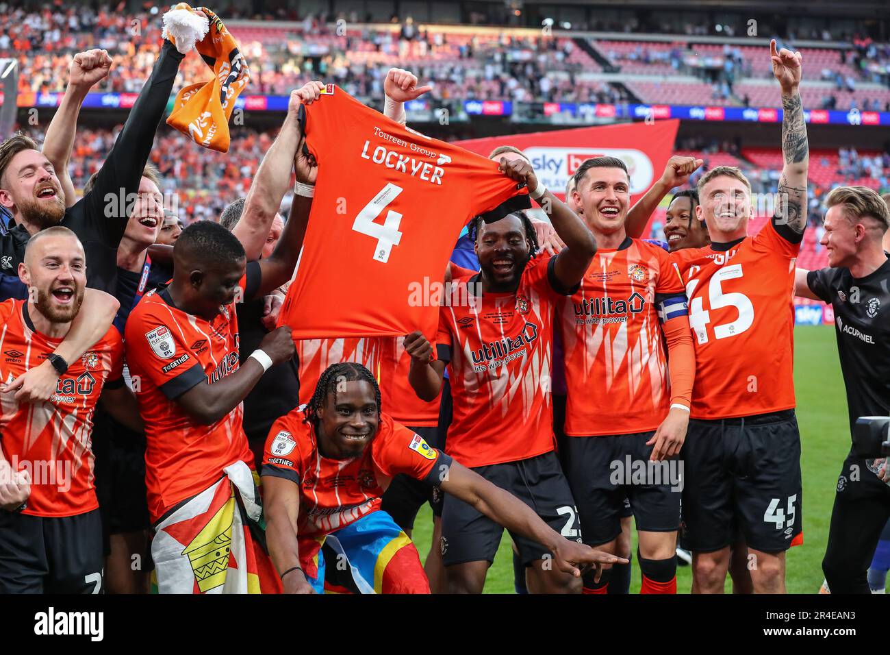 Luton Town players hold up Tom Lockyer #4 of Luton Town shirt after he ...