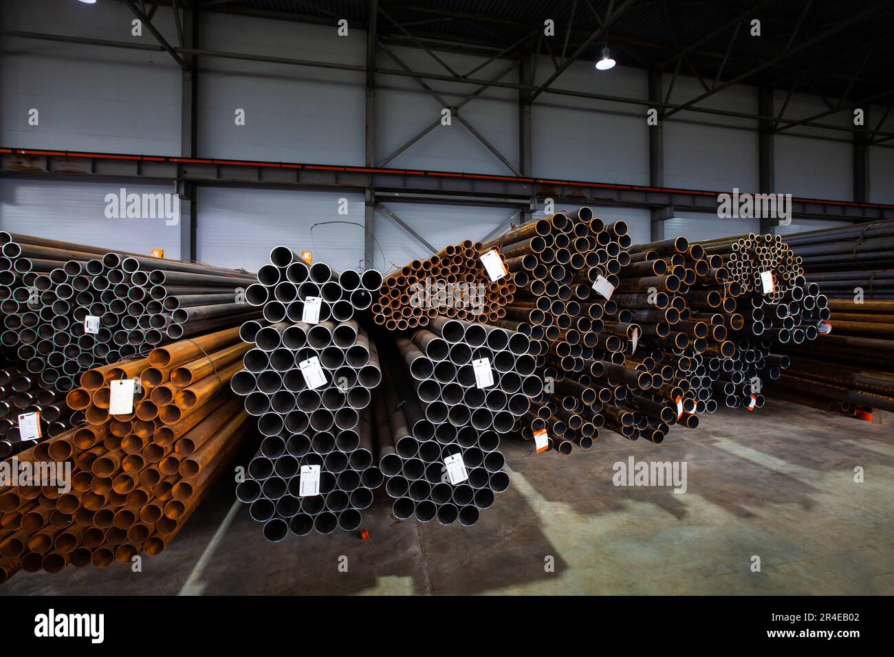 Stack of steel pipes in hangar Stock Photo - Alamy