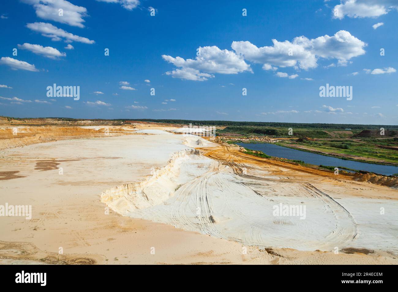 Panorama of white sand quarry against blue sky and clouds. Open-pit ...