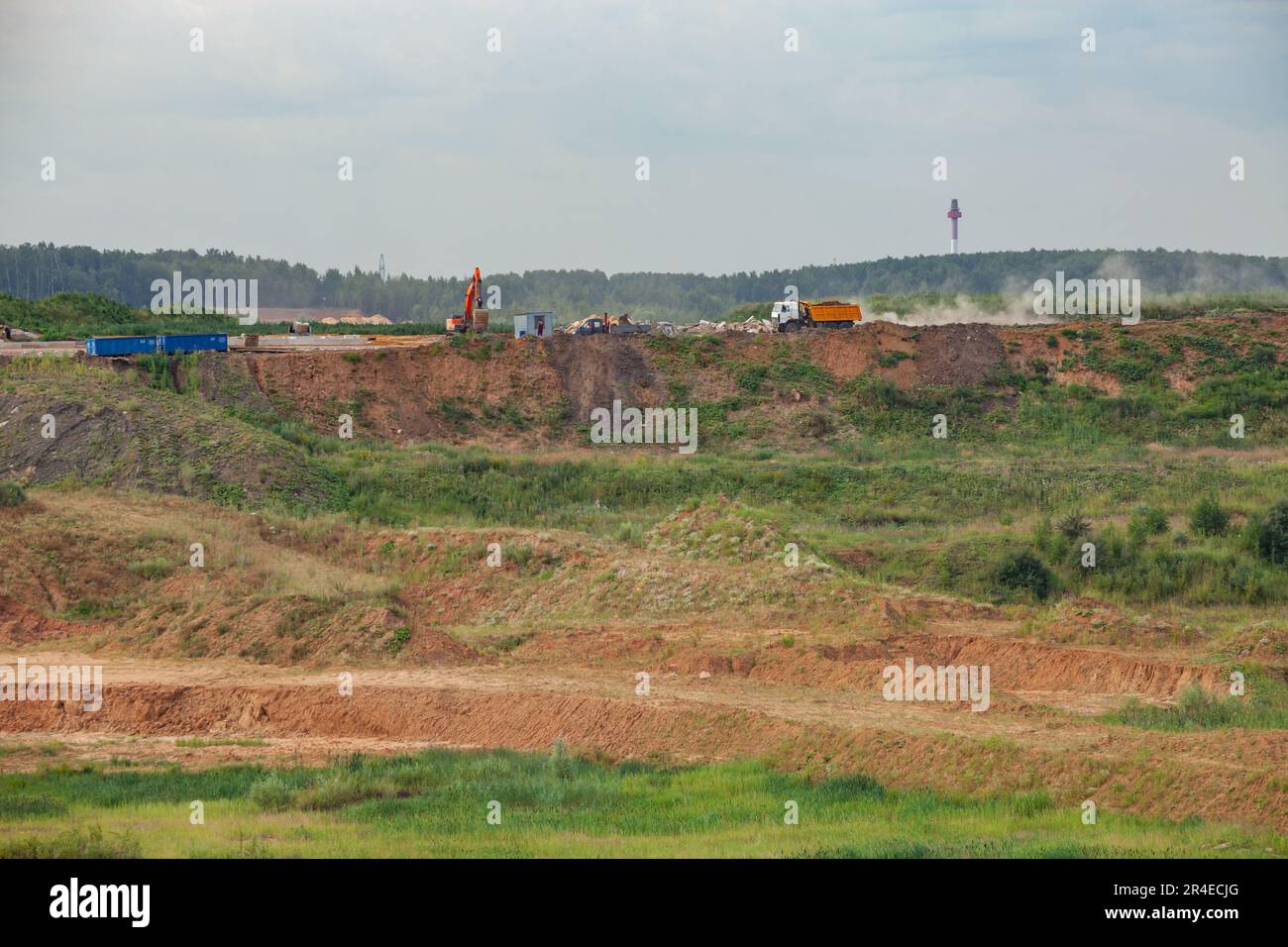Landfill on quarry. Dump trucks unloads garbage. Dirt cloud over land ...