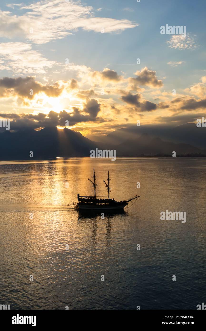 A single ship silhouetted against a beautiful sunset sky on the open ...