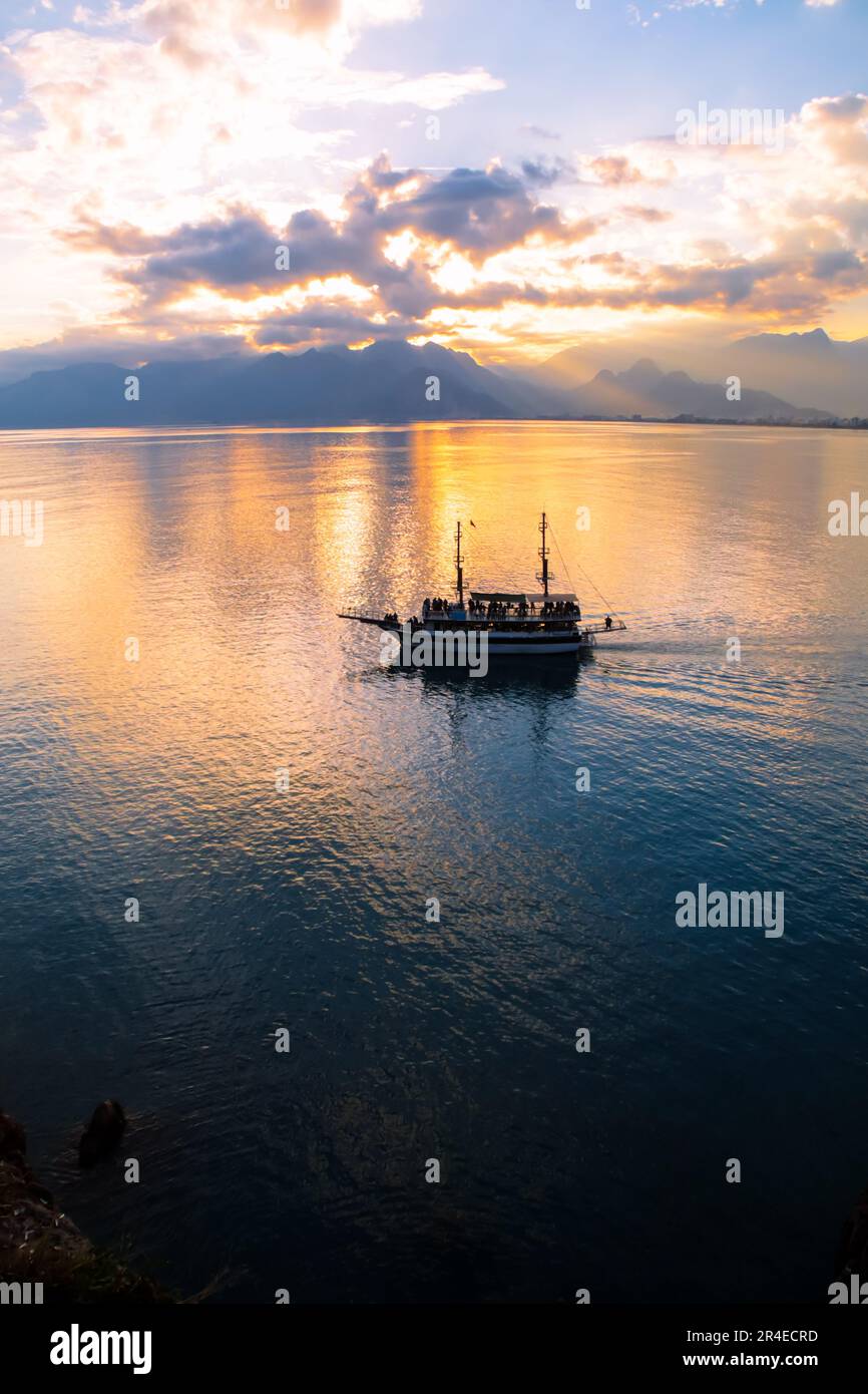 A majestic sailing ship silhouetted against a stunning sunset sky ...