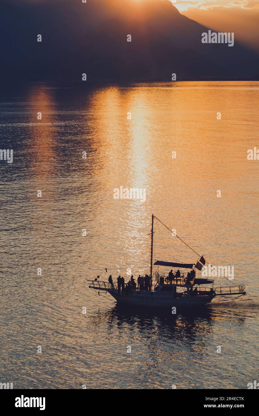 A single ship silhouetted against a beautiful sunset sky on the open ...