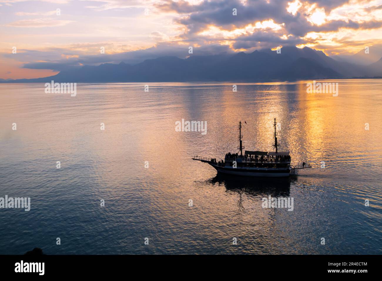 A single ship silhouetted against a beautiful sunset sky on the open ...