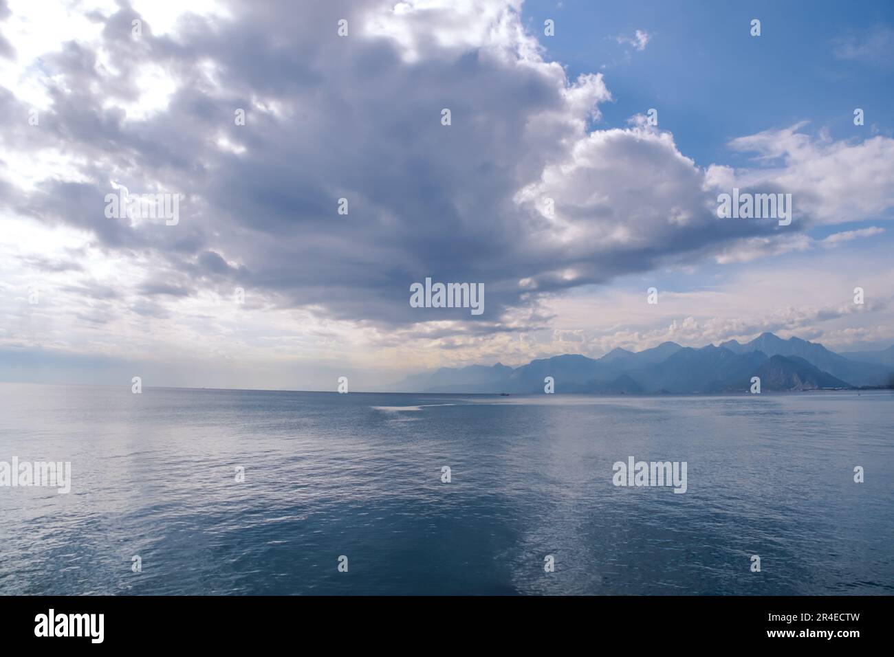 A landscape featuring a body of water reflecting the cloudy sky above ...