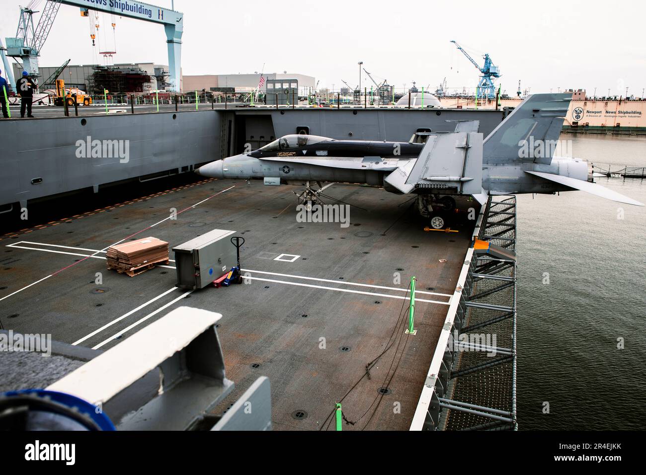 An F/A-18C Hornet, training aircraft is elevated to the flight deck ...