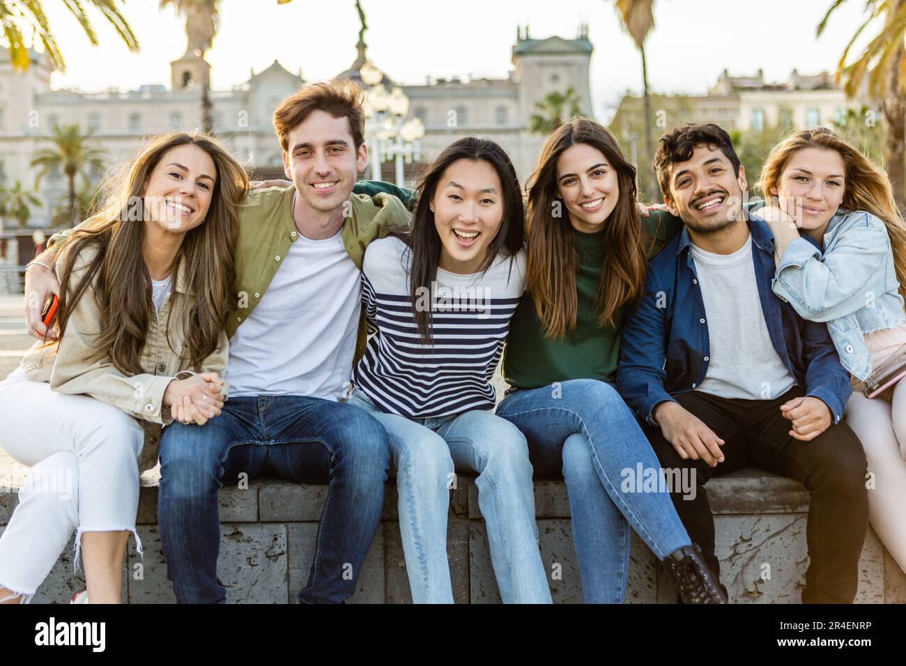 Group of diverse young people embracing each other sitting together ...