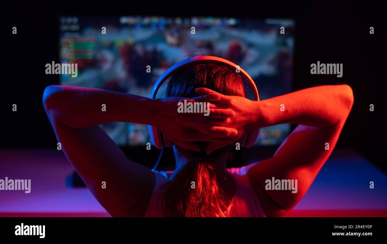 Caucasian woman upset after losing a computer game in neon light in the ...