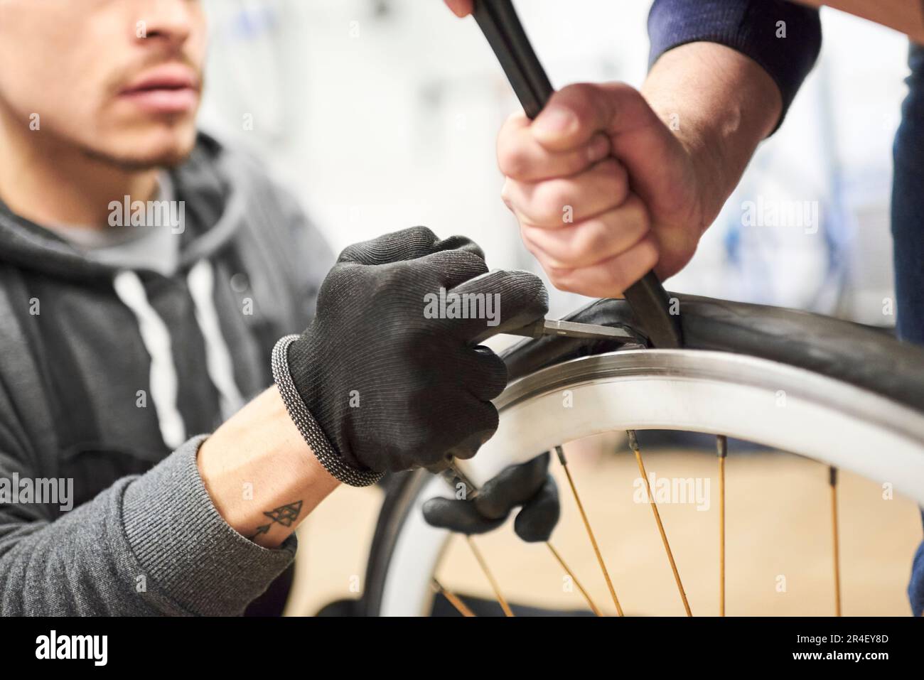 Two men working together collaboratively to remove an airless tire from ...