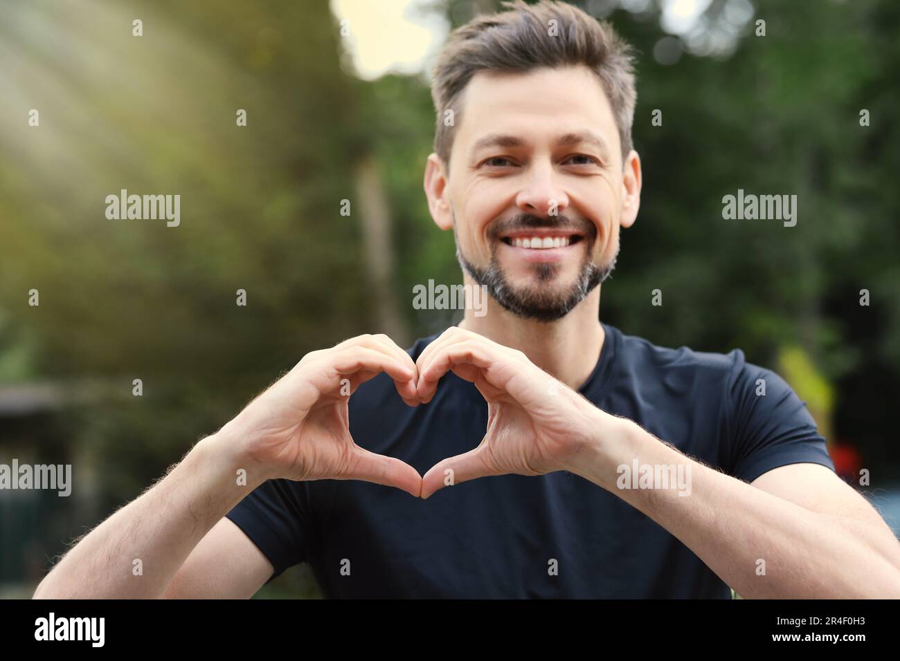 Happy man making heart with hands outdoors Stock Photo - Alamy