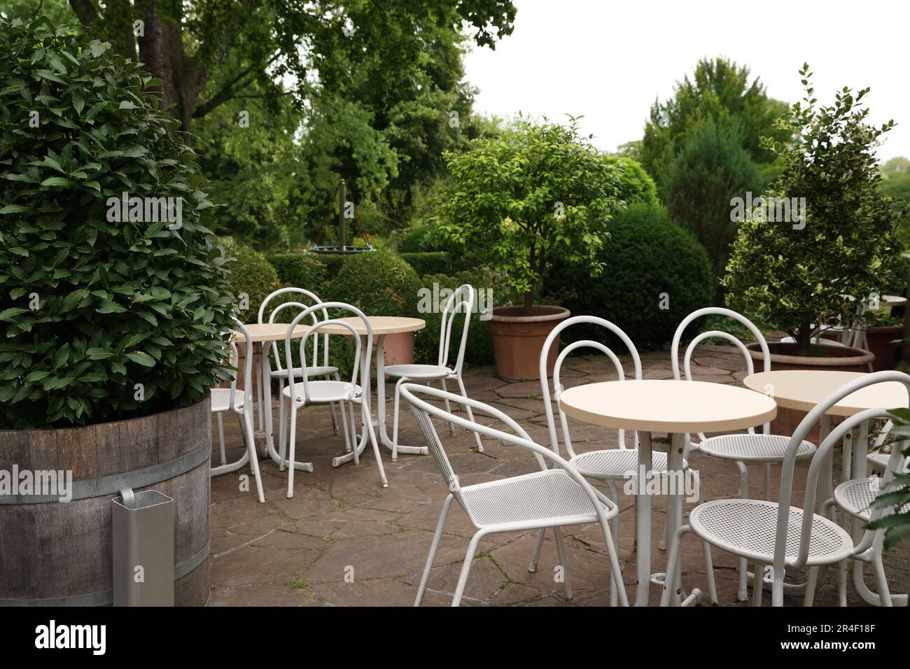 Beautiful garden with tables, chairs and green plants Stock Photo - Alamy
