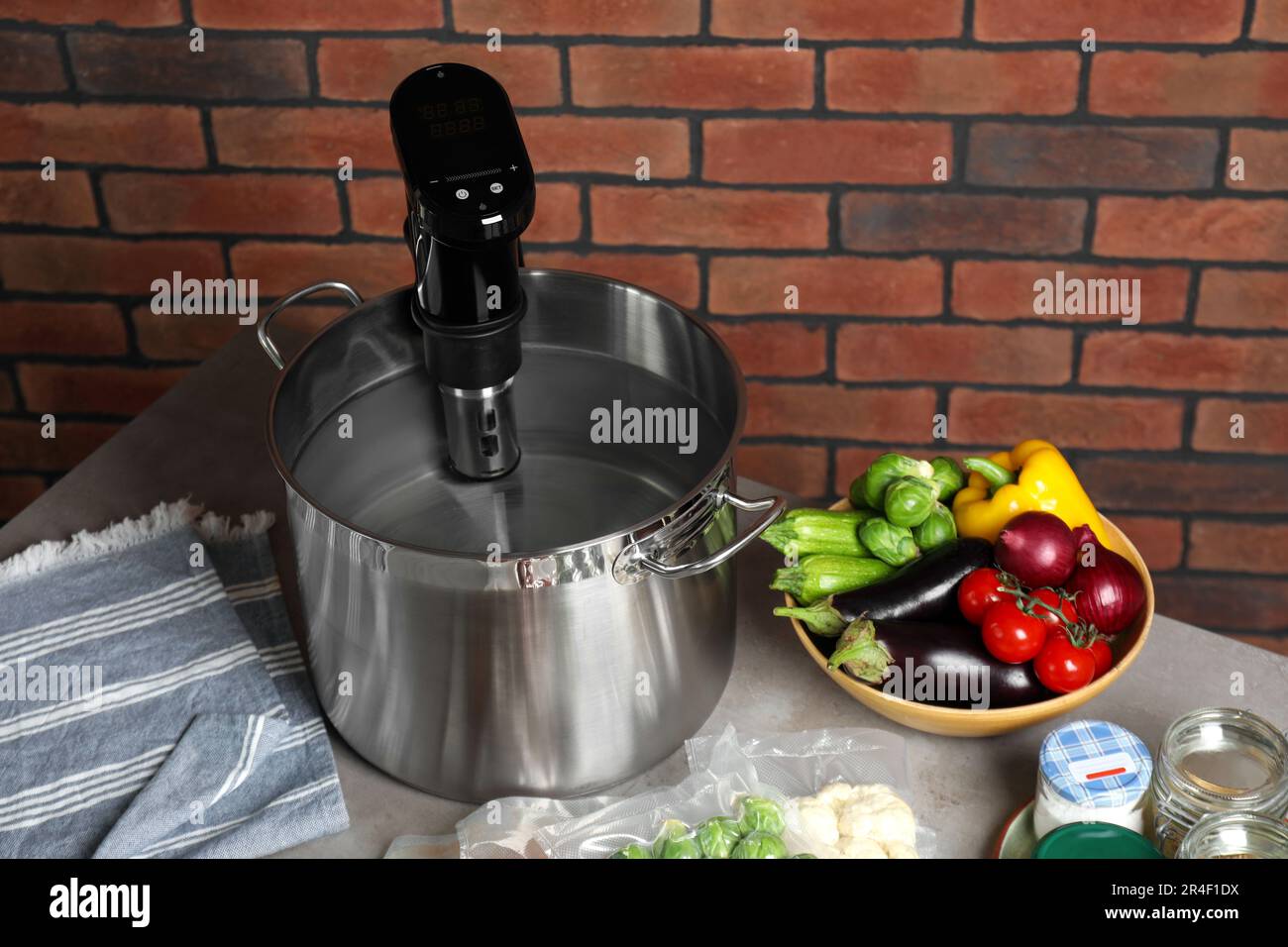 Sous vide cooker in pot and ingredients on table. Thermal immersion ...