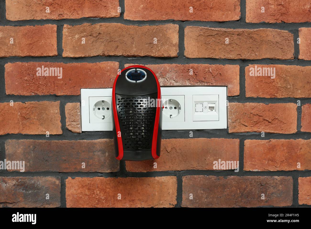 Compact electric heater charging from socket indoors Stock Photo - Alamy