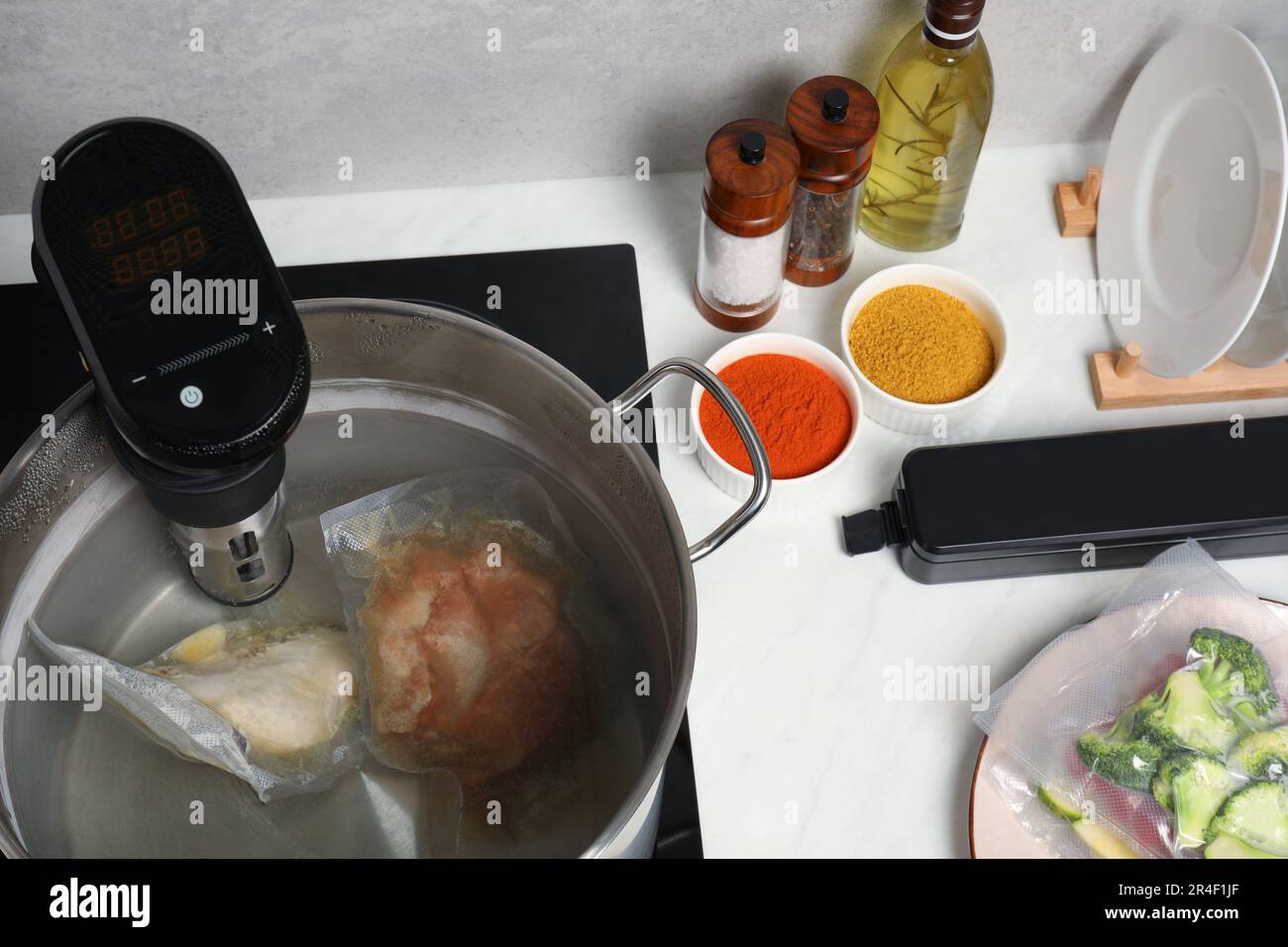 Thermal immersion circulator and vacuum packed meat in pot on table ...
