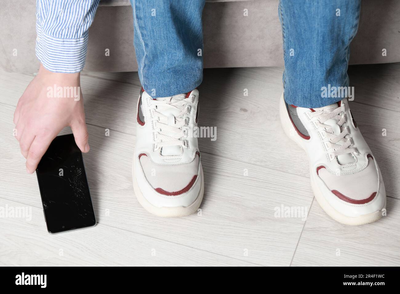 Man taking dropped smartphone from floor, closeup. Device repairing ...