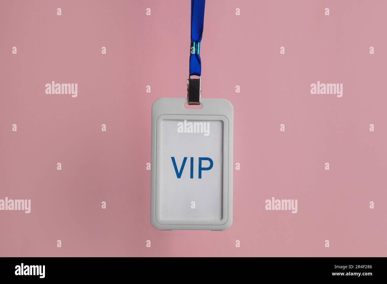 Plastic vip badge hanging on pale pink background Stock Photo - Alamy
