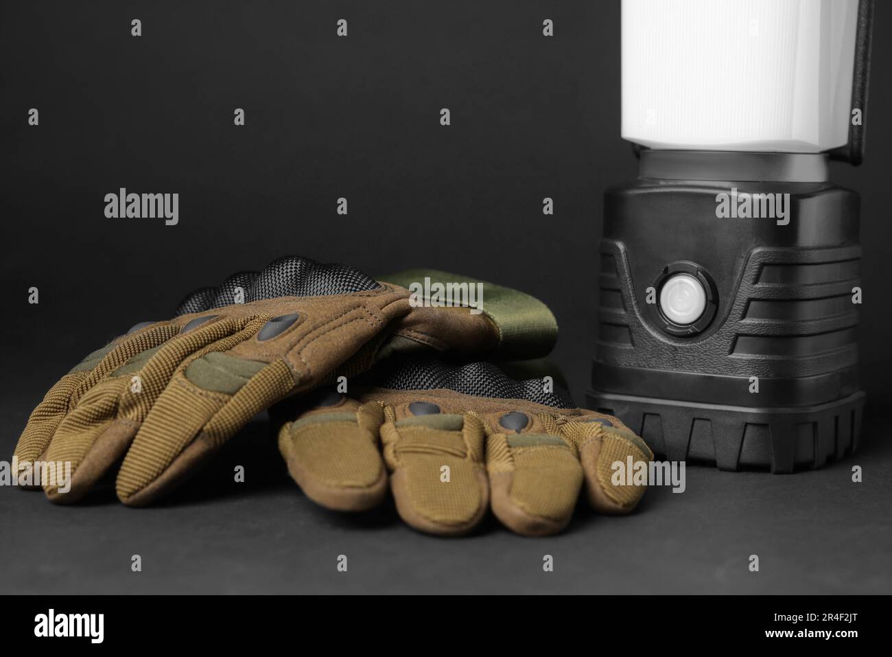Tactical gloves and camping lantern on black background. Military ...