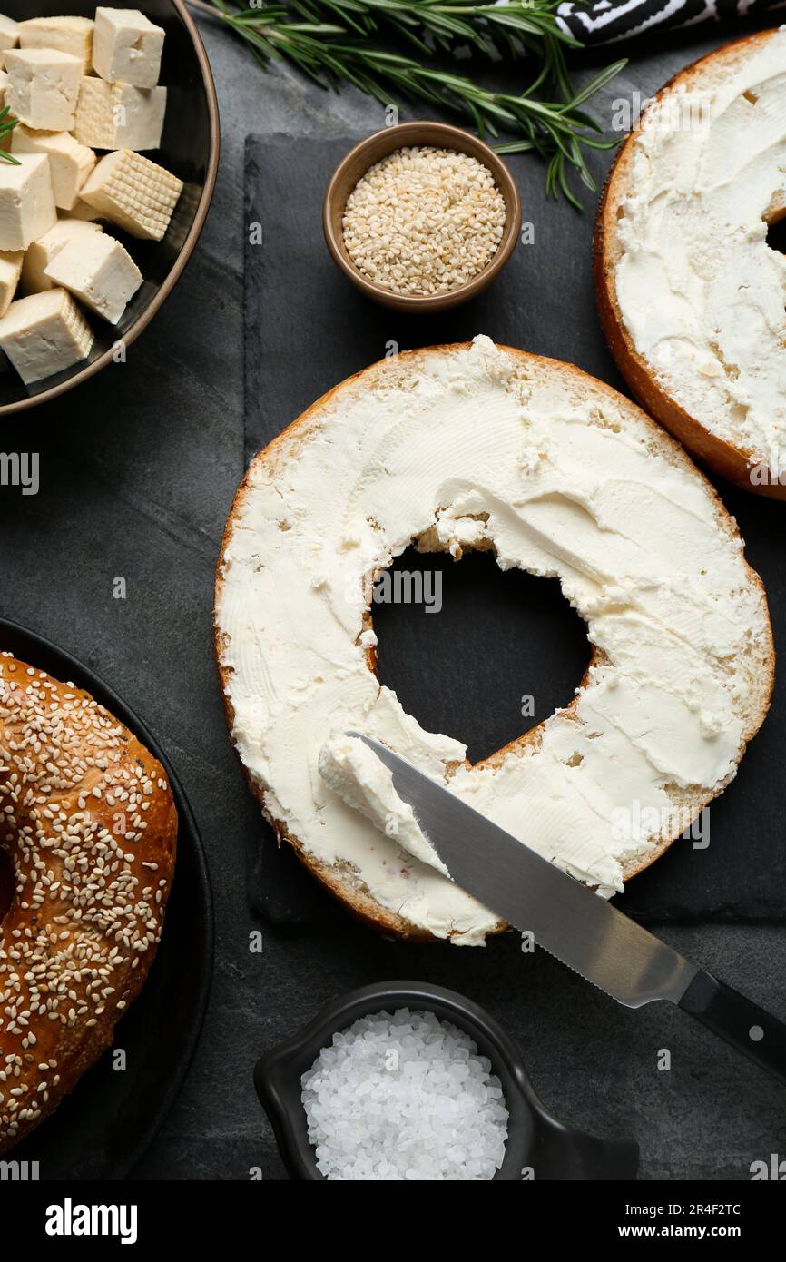 Delicious bagels with tofu cream cheese, sesame seeds and salt on black ...