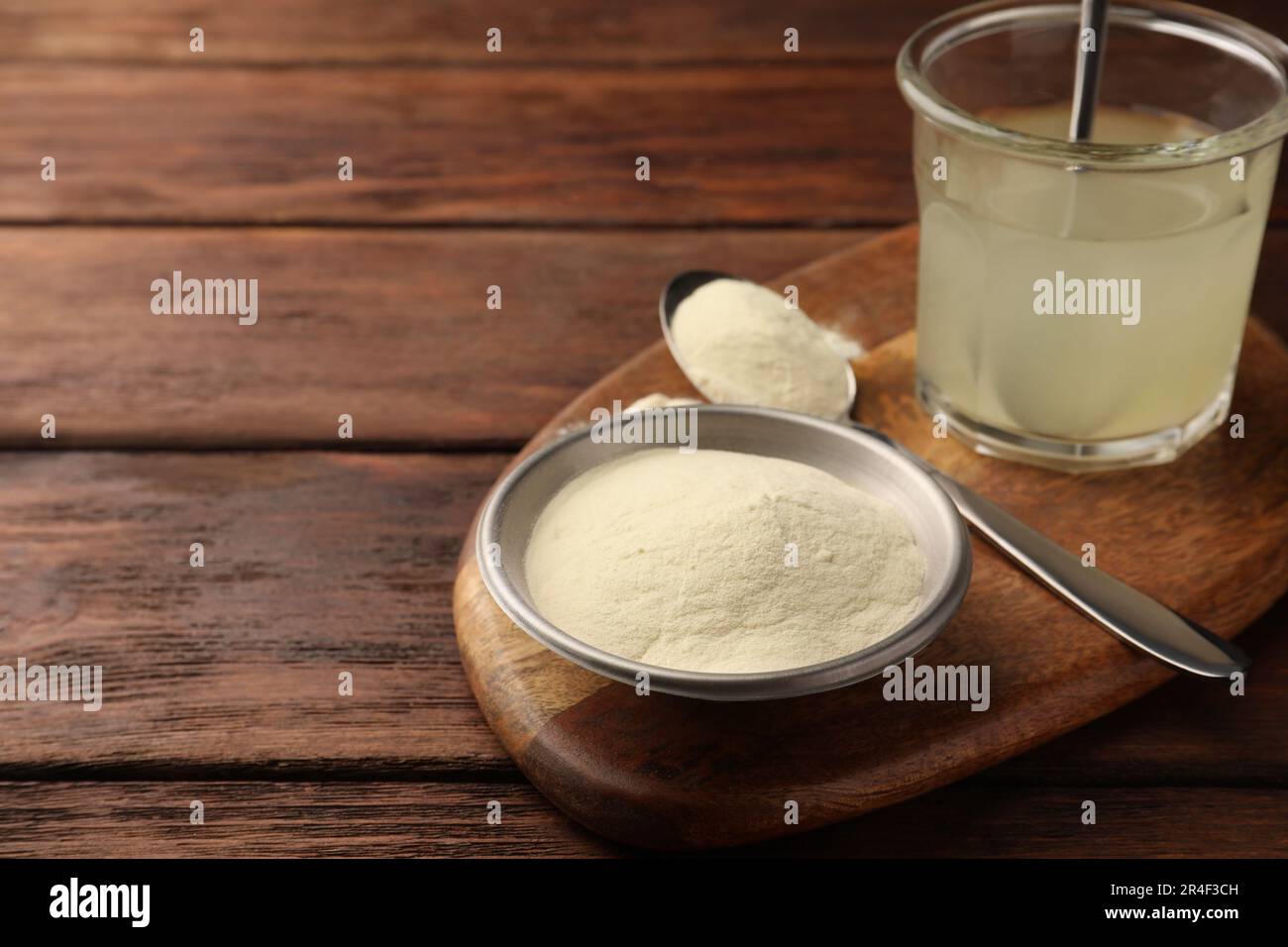 Glass of agar-agar jelly and powder on wooden table. Space for text ...