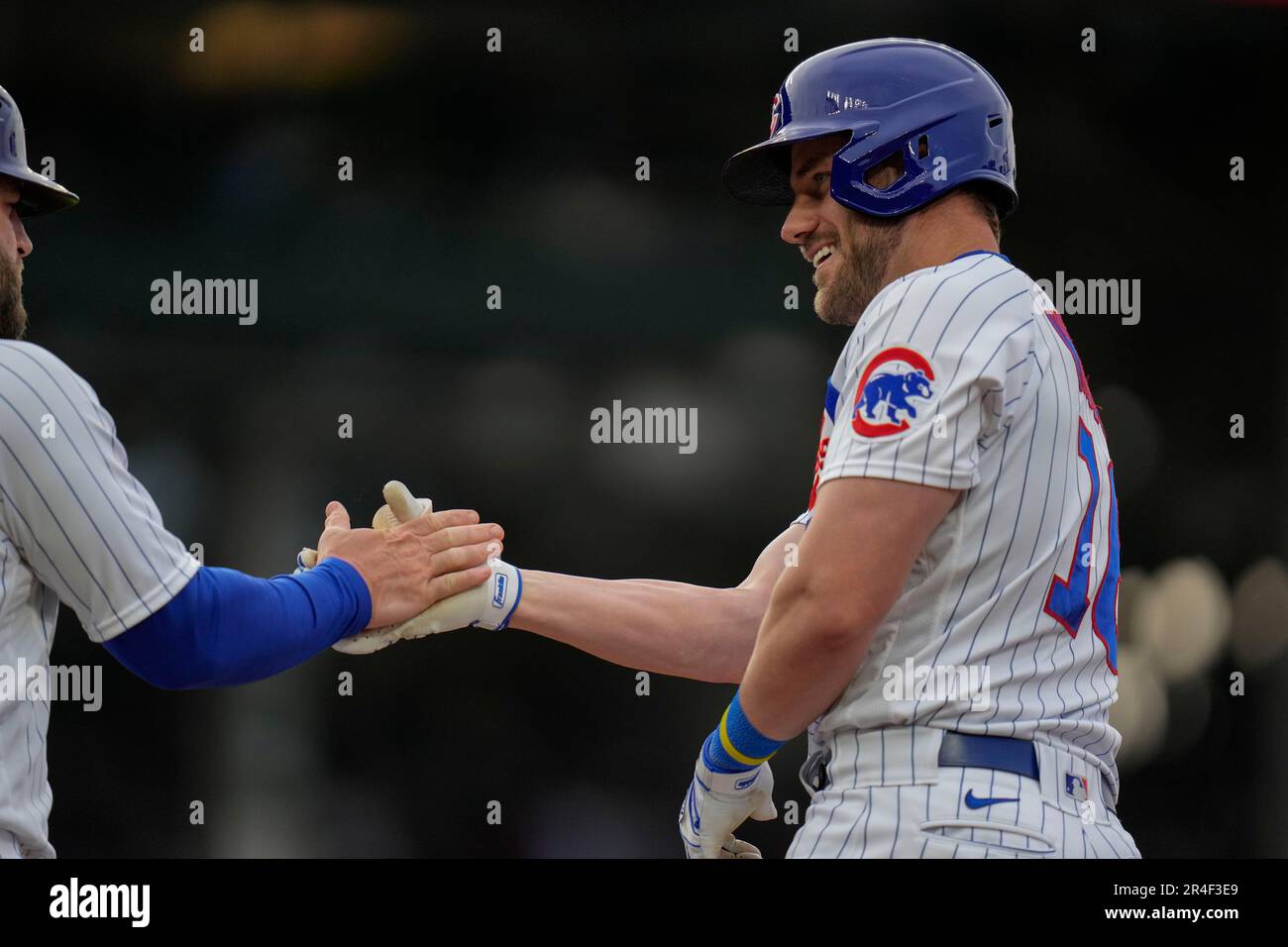 Chicago Cubs' Patrick Wisdom, right, slaps hands with first base coach ...
