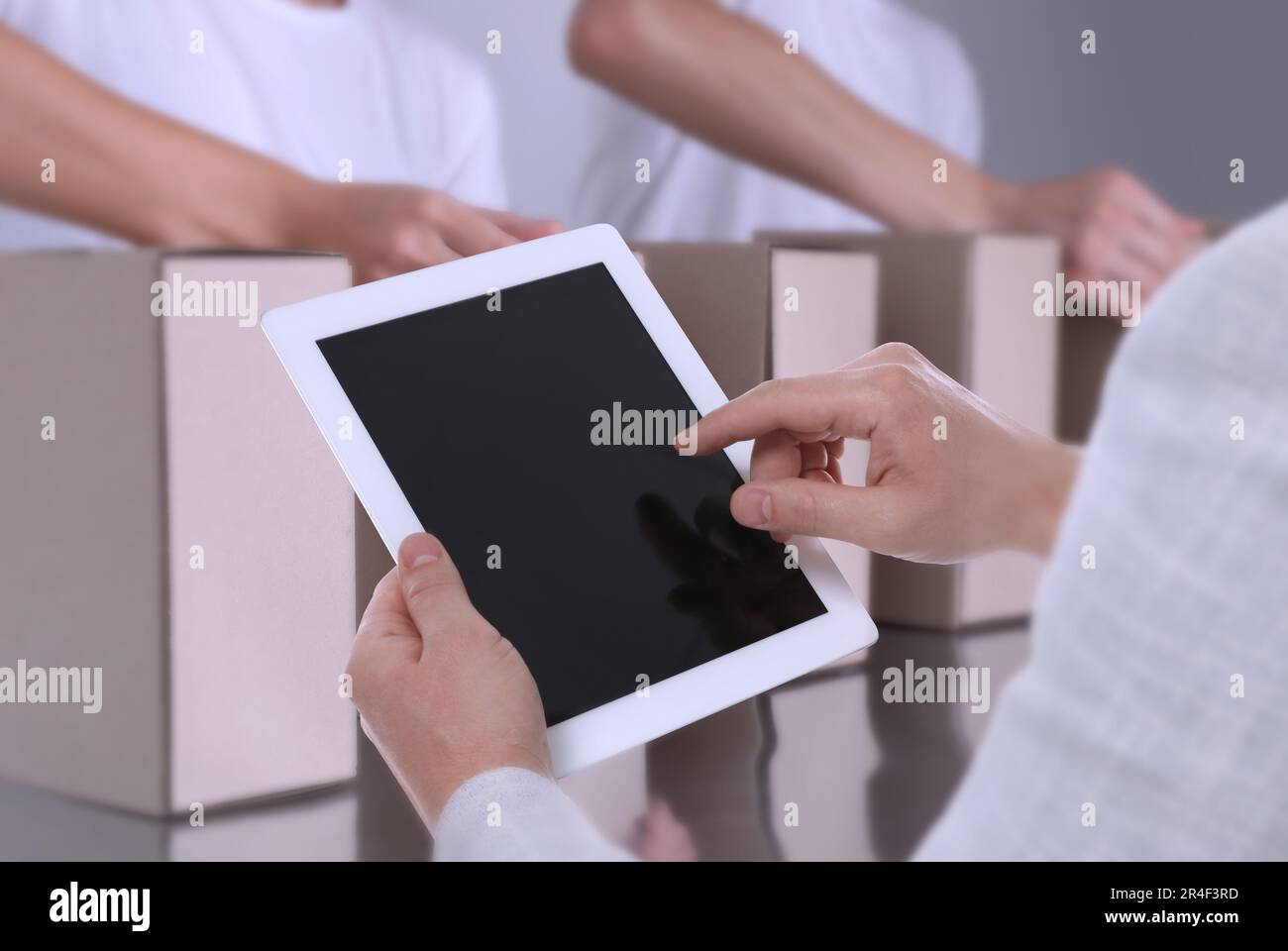 Production line. Manager using tablet while workers folding cardboard ...