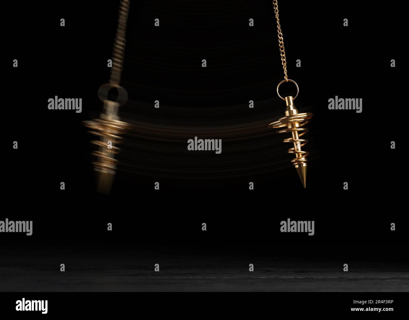Hypnosis session. Pendant swinging over surface on black background ...
