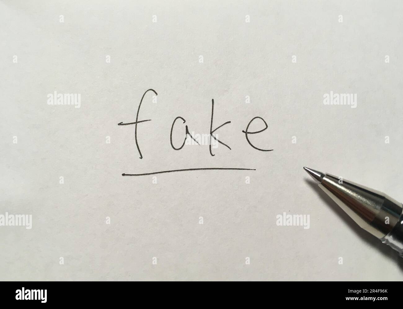 Fake concept word on paper background Stock Photo - Alamy
