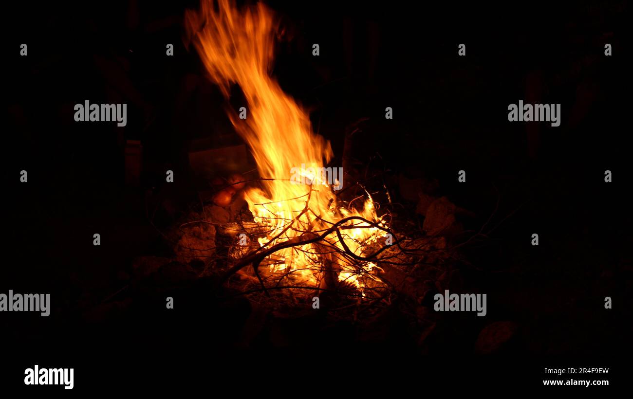 A raging fire burning brightly in the dark night Stock Photo - Alamy