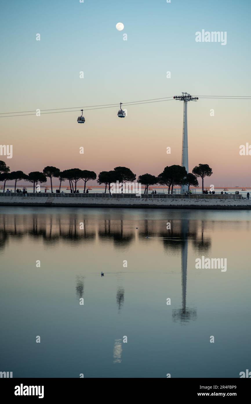 Vertical shot of Lisbon's Enchanting Low-Key Sunset: Full Moon, Pink ...