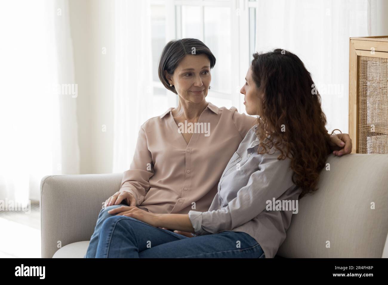 Positive pretty mature mom speaking to daughter woman on couch Stock ...
