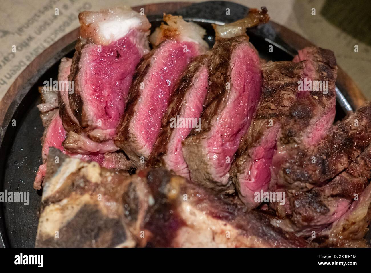 Medium rare Tomahawk meat on plate Stock Photo - Alamy