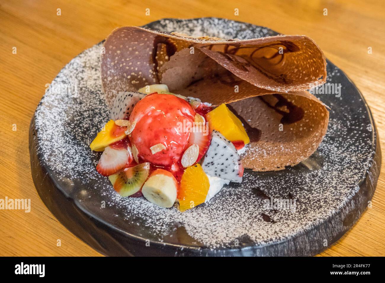 Crepe with ice cream whipped cream and strawberry sauce Stock Photo - Alamy