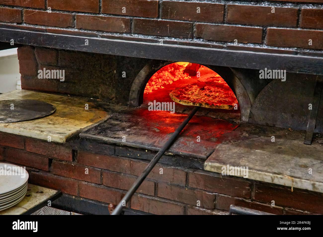 Baked tasty margherita pizza in Traditional wood oven in Naples restaurant, Italy. Original ...