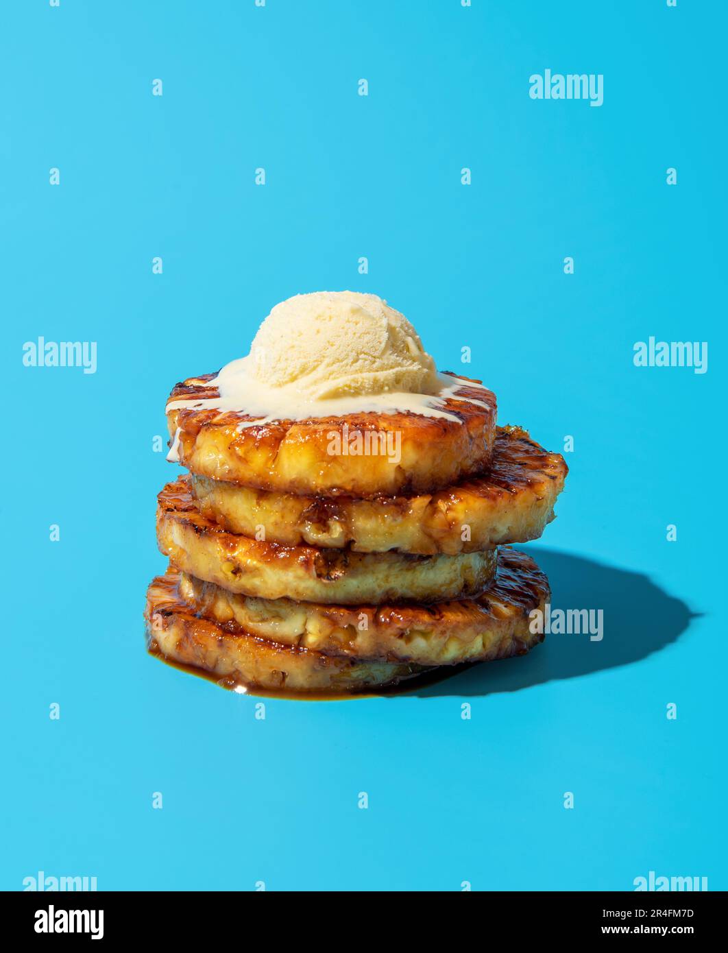 Stack of grilled pineapple rings with a scoop of vanilla ice cream on ...