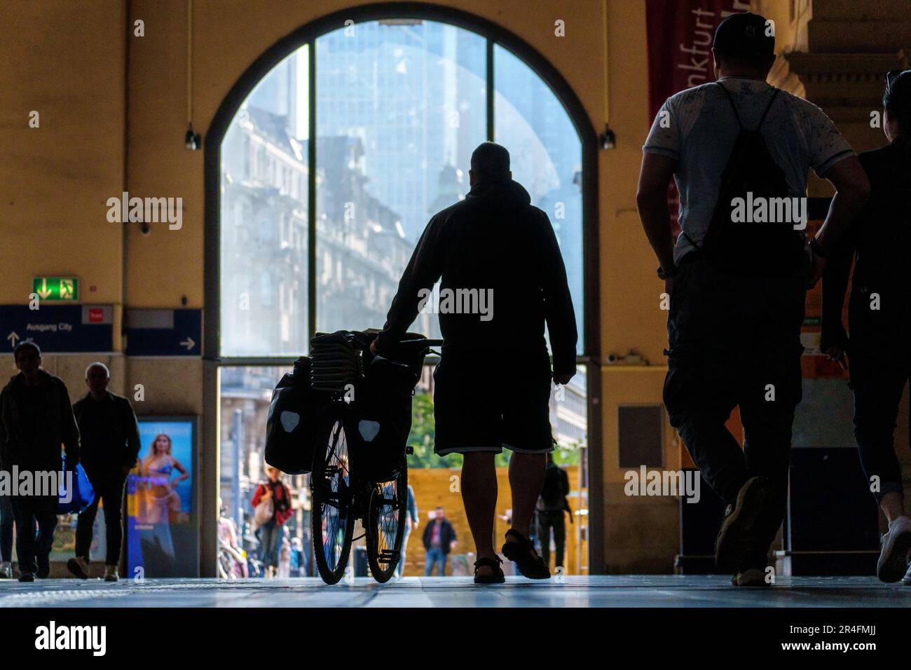 27 May 2023, Hesse, Frankfurt/Main: A man pushes his bicycle through ...