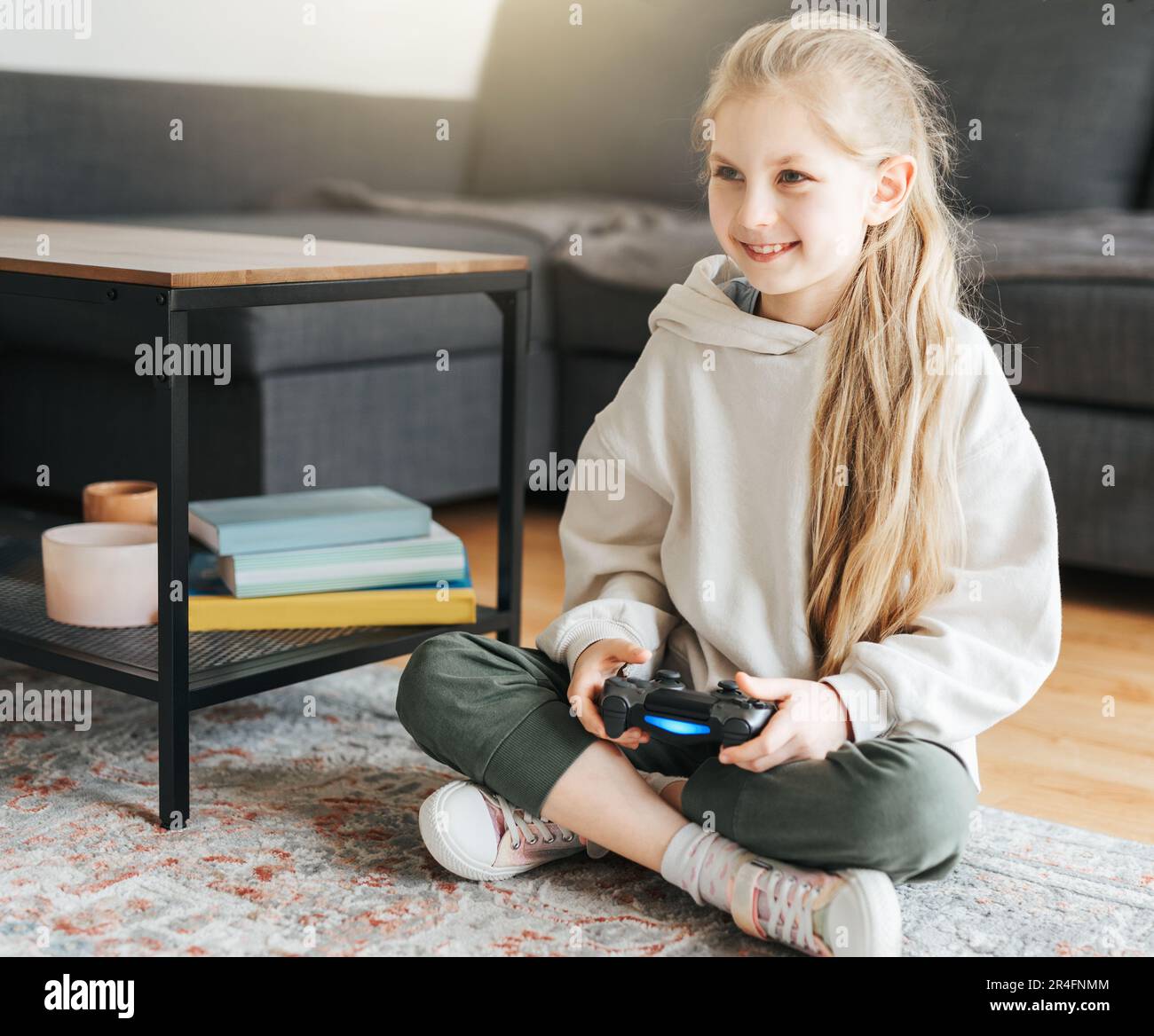 A little girl is playing with a game console at home Stock Photo - Alamy