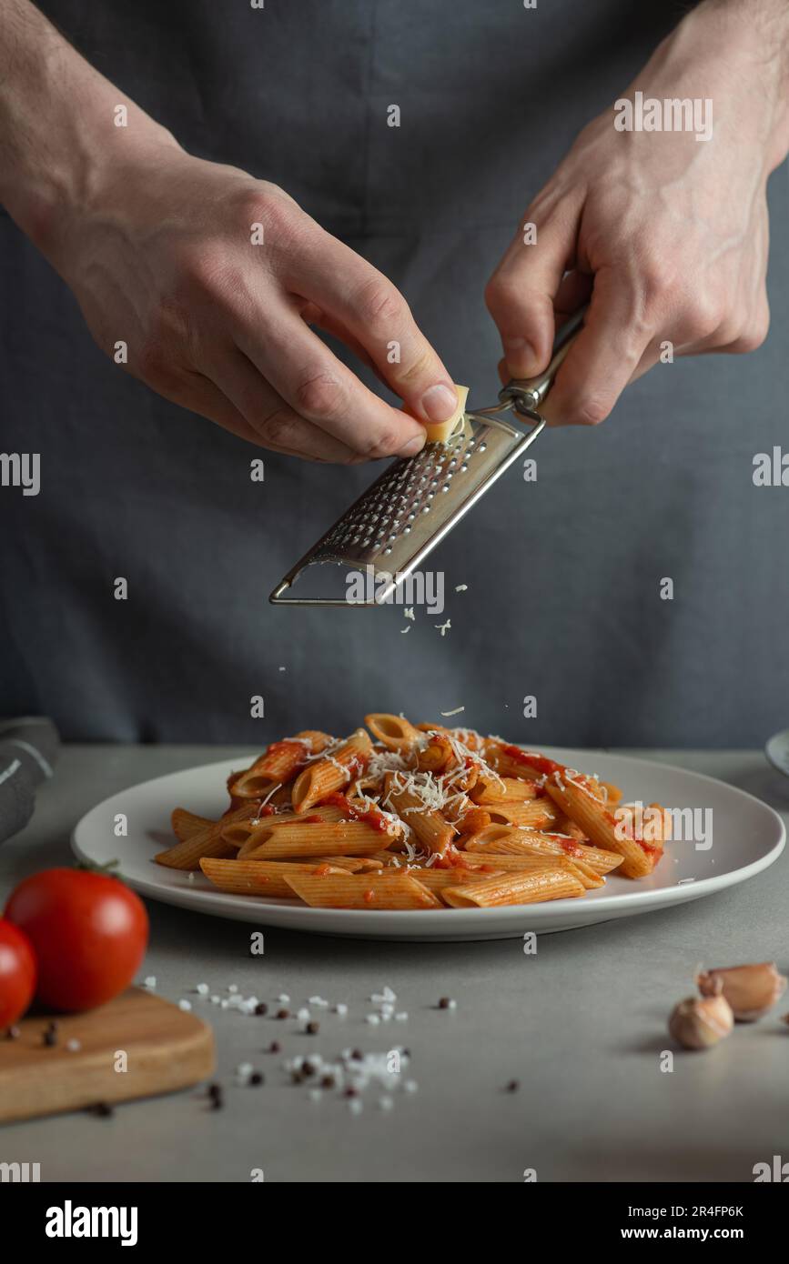Man cooking pasta, grating cheese Stock Photo - Alamy