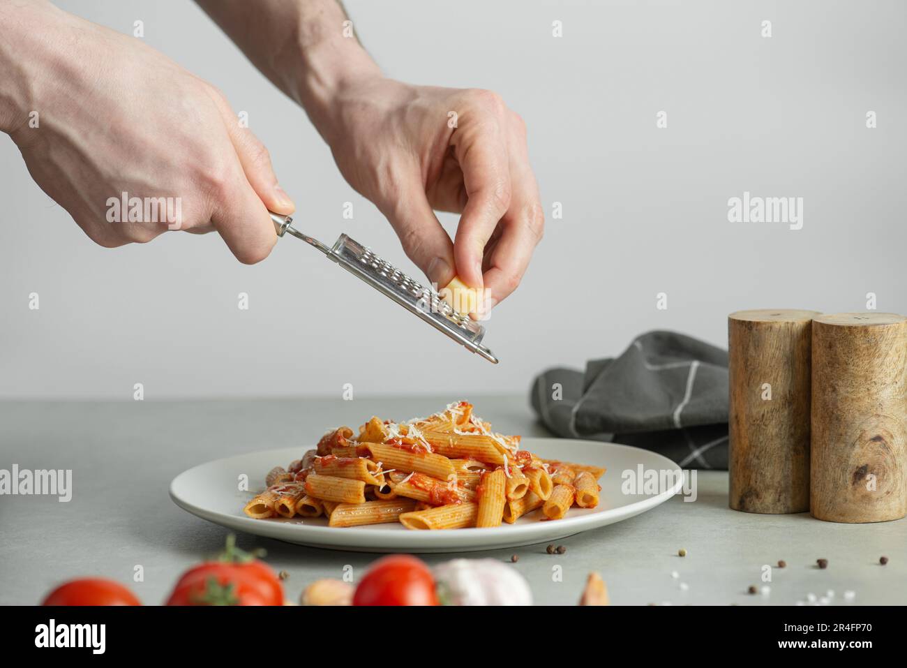 Man cooking pasta, grating cheese Stock Photo - Alamy