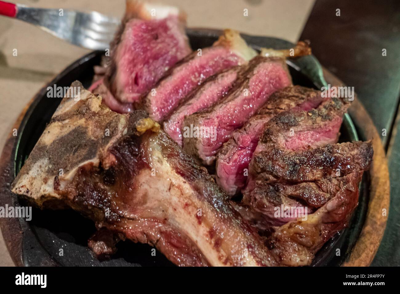 Medium rare Tomahawk meat on plate Stock Photo - Alamy