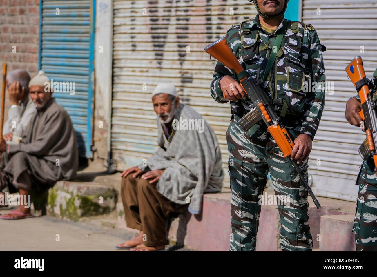 Indian paramilitary soldiers guard as elderly Muslims sit and watch ...