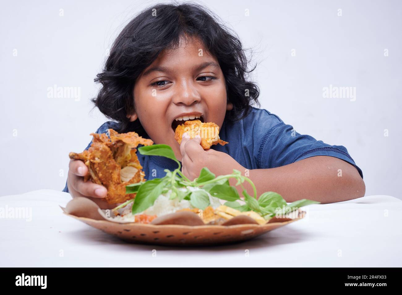 Little Girl Eating Fried Chicken, rice with vegetable and spicy souce ...
